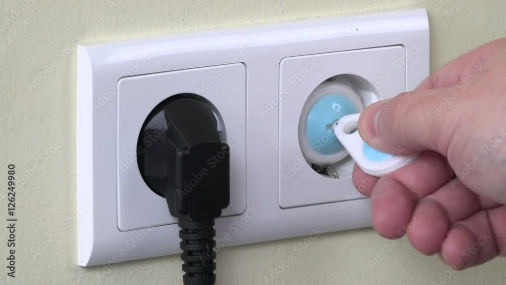 Hand remove safety plug from electricity outlet and insert plug wire ...