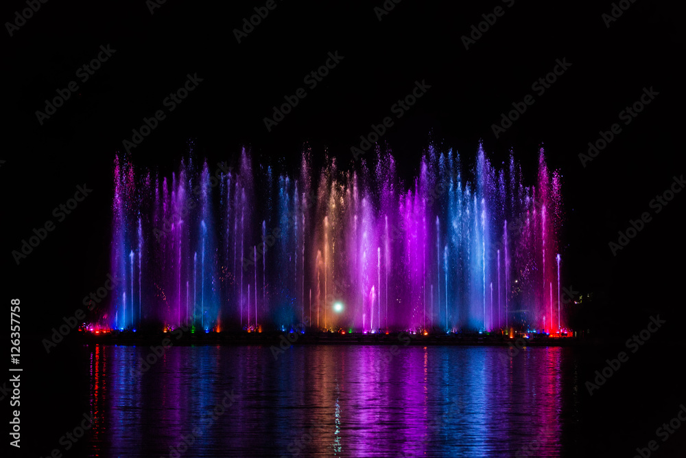 Beautiful fountain dancing show with reflection on water at night ...