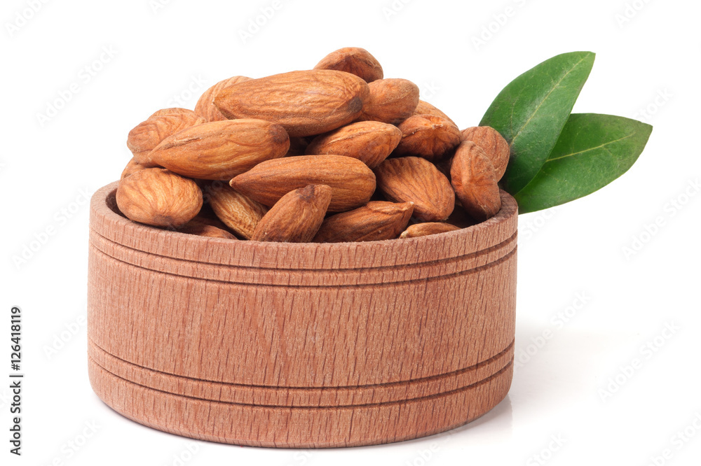 heap of almonds in their skins and peeled with leaf isolated on white ...