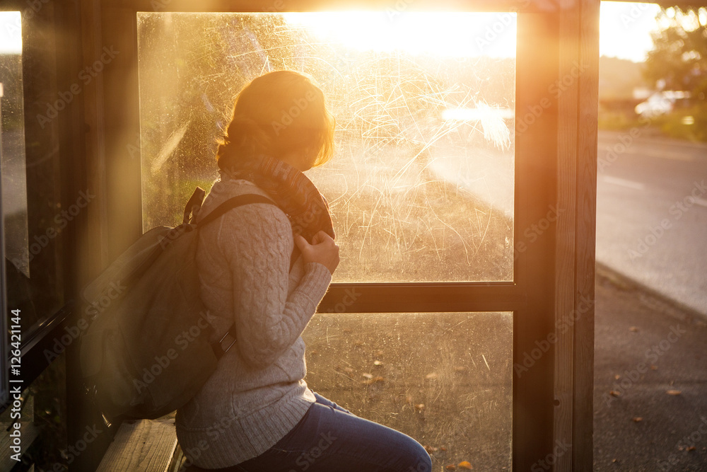 Sad girl looks at the sunset. A girl holding a backpack. Thoughtful ...