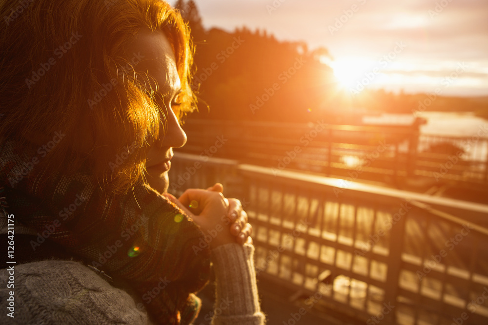 Sad girl looks at the sunset. A girl holding a backpack. Thoughtful ...