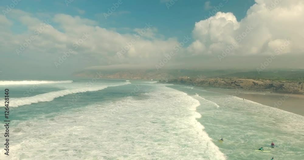 Birds eye view of ocean waves and group of surfers catching the waves ...