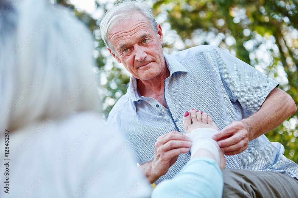 Mann verbindet verstauchten Knöchel von Frau Stock Photo | Adobe Stock