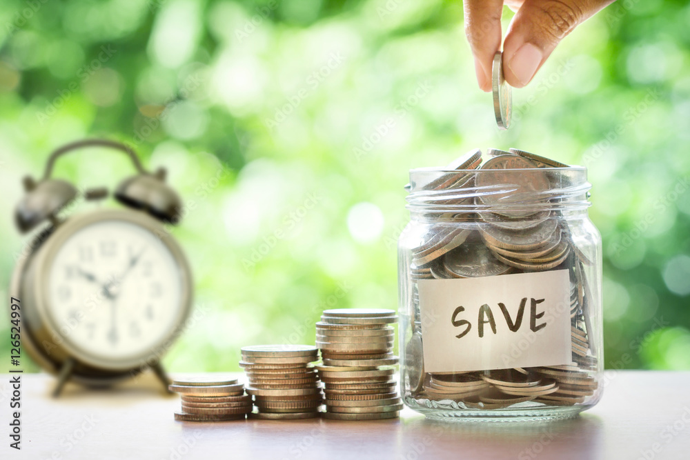 Hand putting Coins in glass jar , time for money saving financi Stock ...