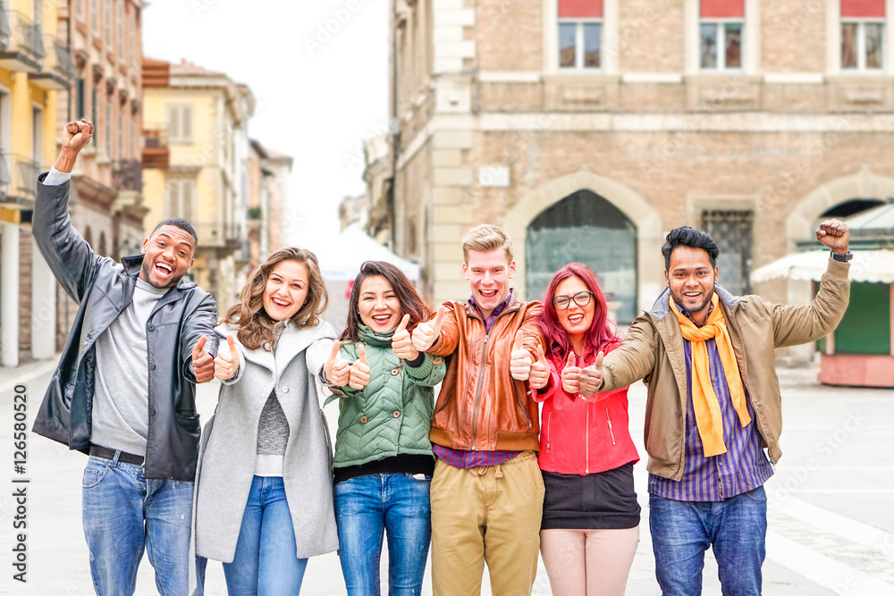 Multicultural group of friends thumbs up exulting successful day at old ...