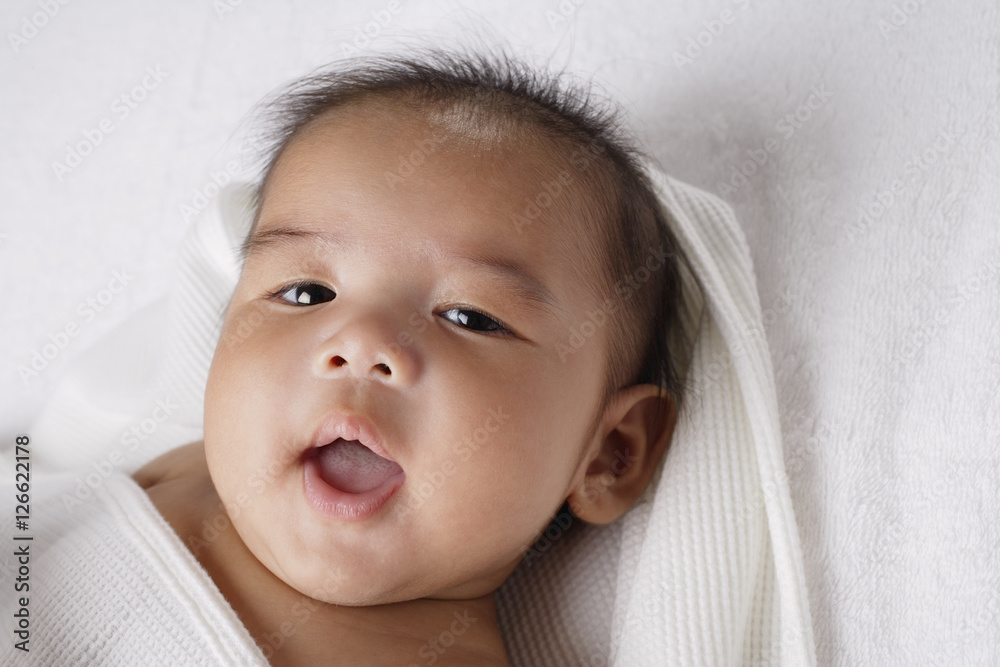 Head shot of Chinese baby smiling at camera. Stock Photo | Adobe Stock