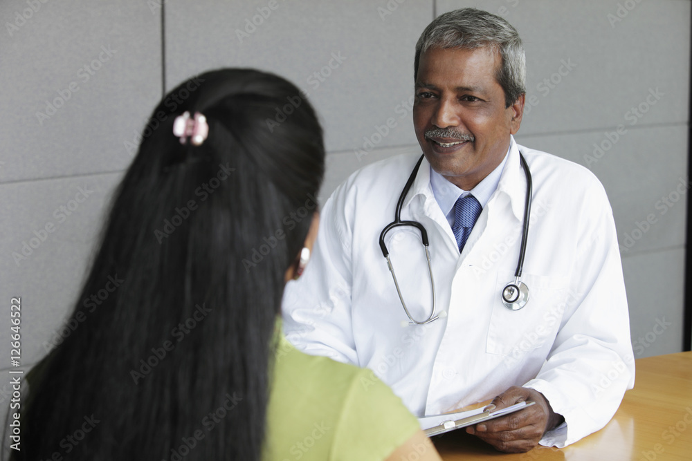 Indian doctor talking to female patient Stock Photo | Adobe Stock