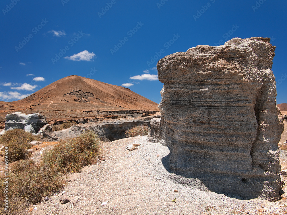 A carved rock sculpted by wind erosion against background of deep blue ...