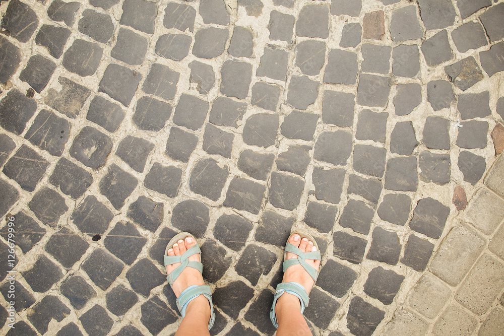 Female traveler looking down at her tired wounded feet. Point of view ...