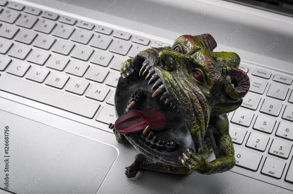 Trolling and cyber bullying concept with a troll sitting on a laptop's ...