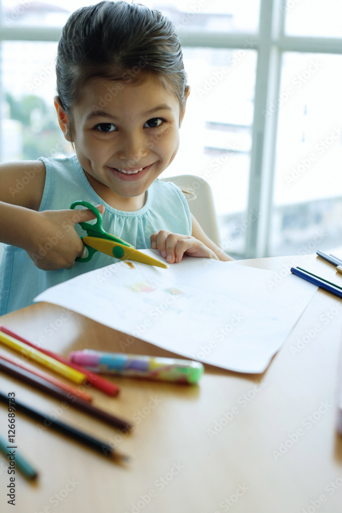 Young girl holding scissors, cutting paper, smiling at camera Stock ...