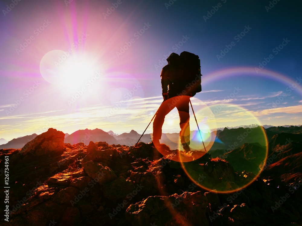 Lens flare defect.Man hiker with rucksack walk on rocky peak. Man ...