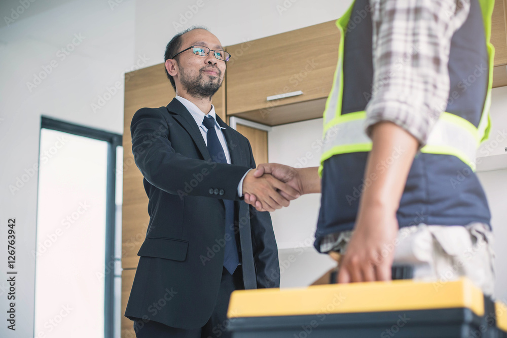 Customer Shaking Hands With Builder. Cheerful industrial manager and ...