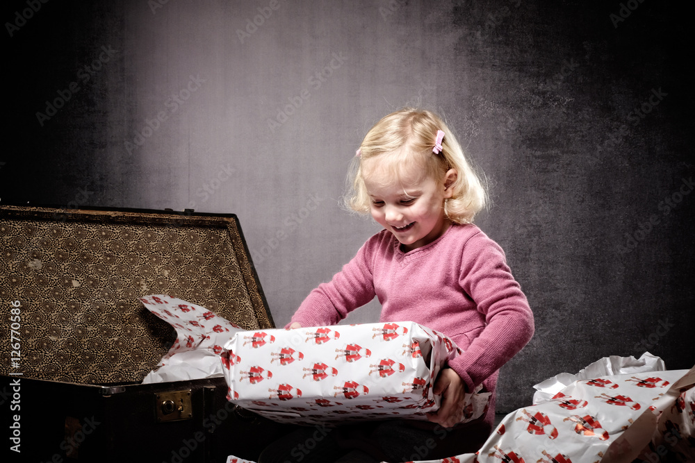 blondes mädchen beim geschenk auspacken Stock-Foto | Adobe Stock