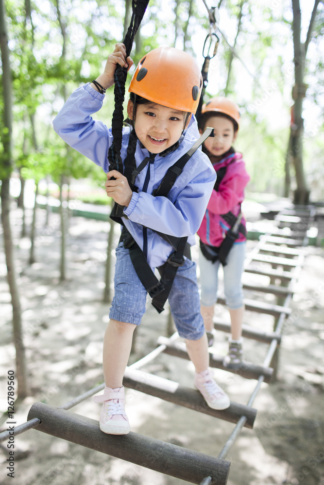 Happy children playing in tree top adventure park Stock Photo | Adobe Stock