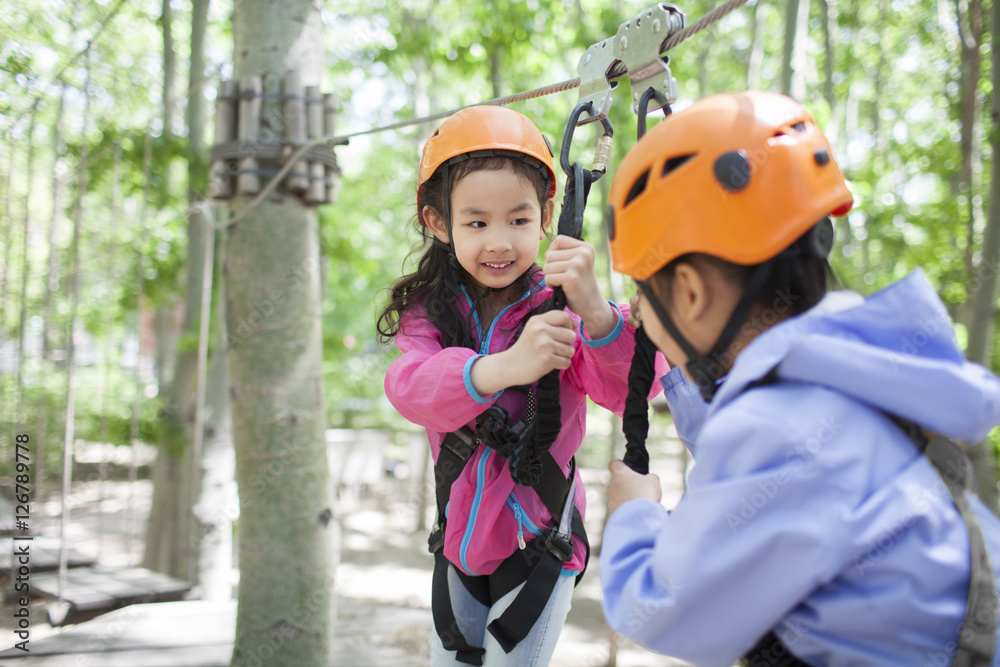 Happy children playing in tree top adventure park Stock Photo | Adobe Stock
