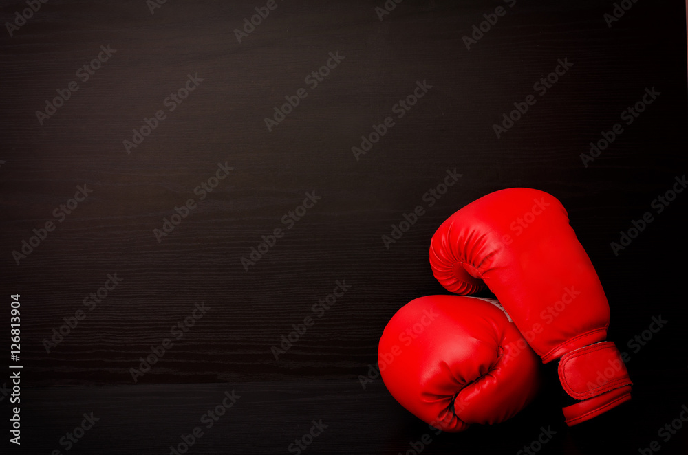 Red boxing gloves on a black background in the corner of the frame ...
