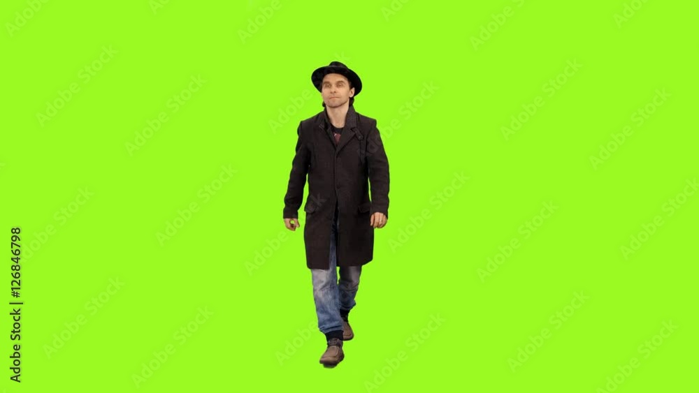 Front view of a man walking & smiling on a green screen background ...