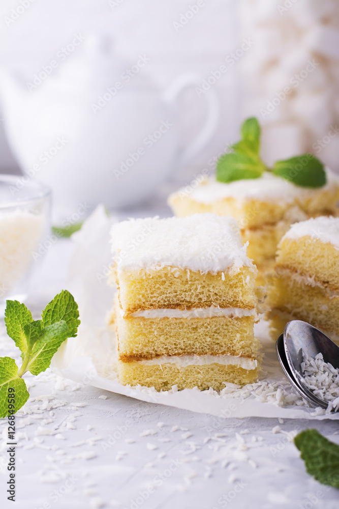 Homemade fresh sponge cake in the coconut cream and flakes on the feast ...