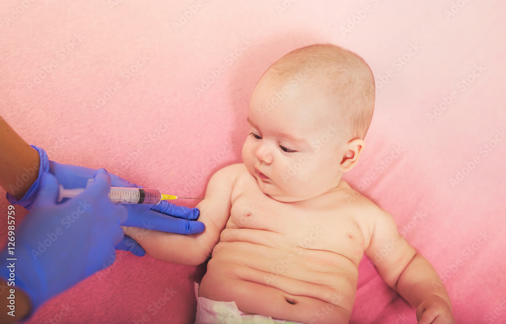 Baby receiving vaccine. Pediatrician giving a baby girl intramuscular ...