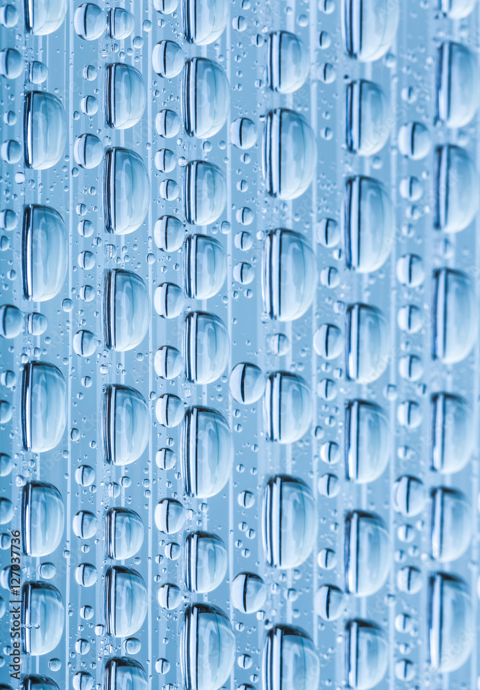 Blue water drops of on treat water-repellent surface in macro lens shot ...