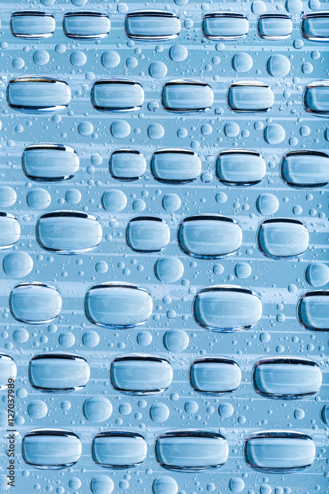 Blue water drops of on treat water-repellent surface in macro lens shot ...