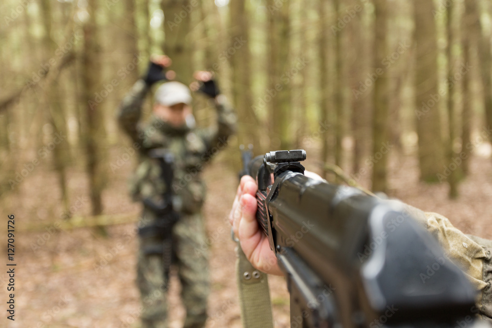 soldiers in the coniferous forest with a gun, aiming ready for battle ...