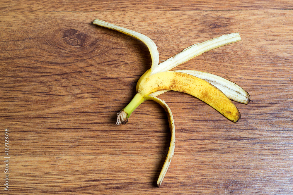 Banana peel on a wooden table. The danger of falling. Pollution. Stock ...