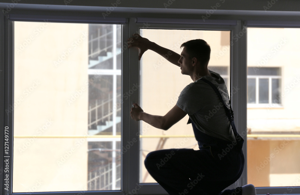 Construction worker installing window in house Stock Photo | Adobe Stock