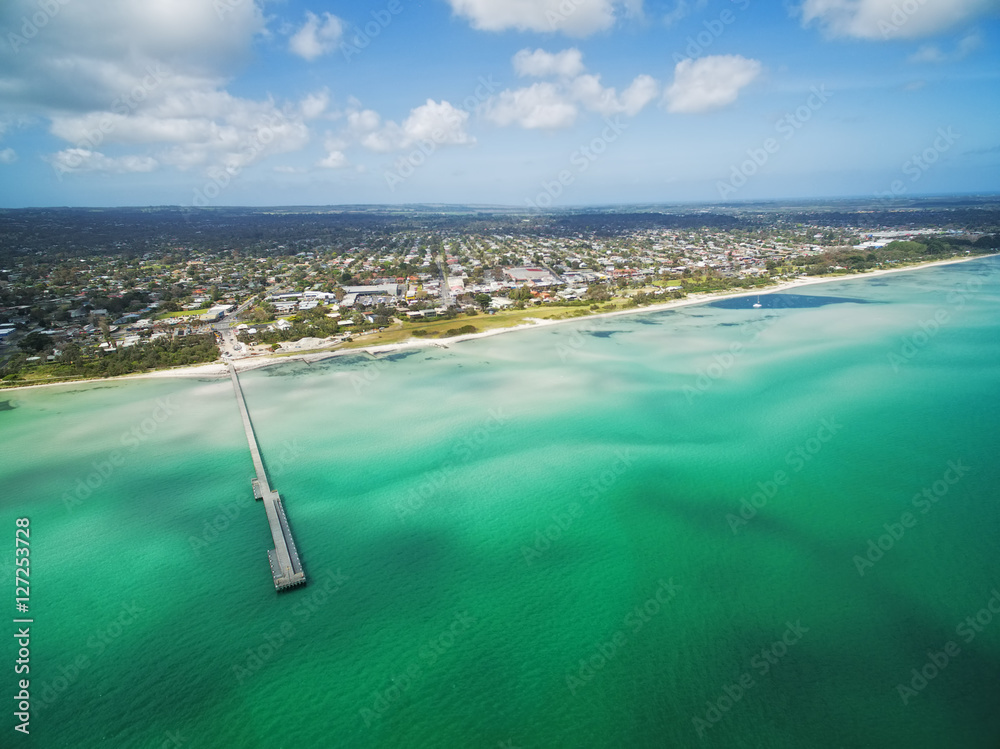 Aerial view of Rosebud pier and coastline featuring vivid turquoise bay ...