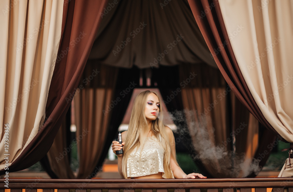 Sexy girl smokes electronic cigarette. The model vaper vaping a ...