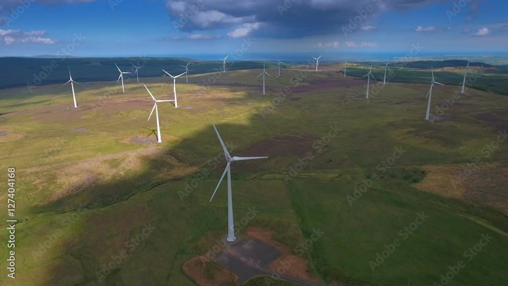 The aerial view of the big windmills in the field turning around on the ...
