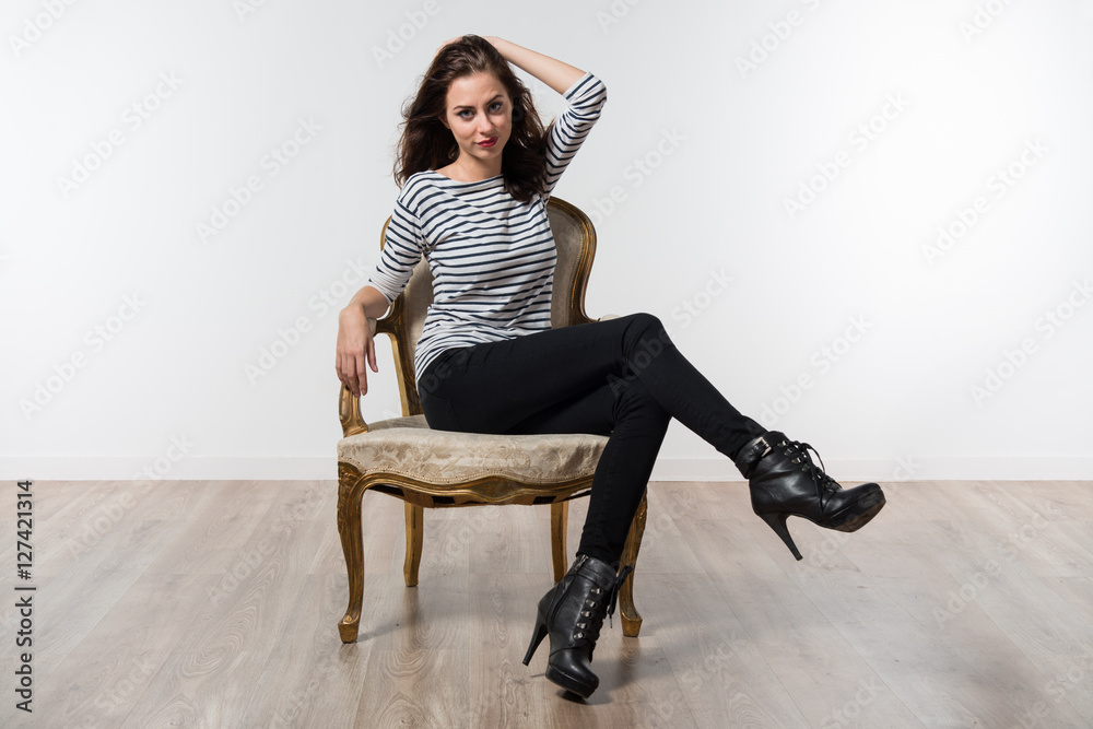 Beautiful model woman posing in studio with a vintage armchair Stock ...