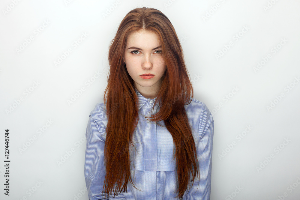 Young serious angry redhead beautiful woman in shirt portrait on a ...