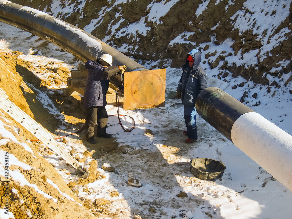 The workers engaged in the construction of the pipeline. Welders build ...