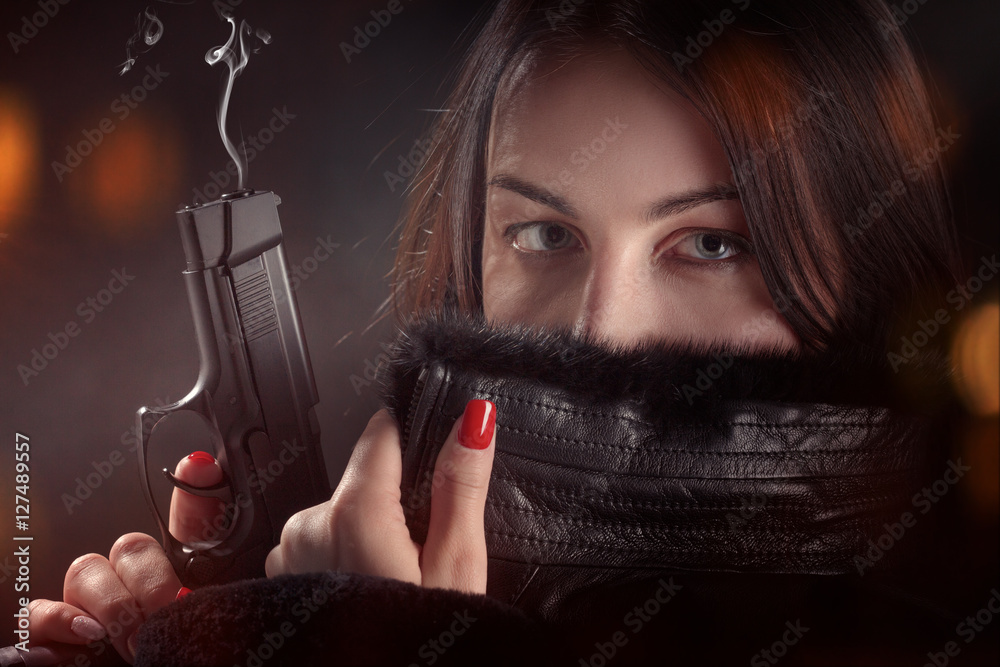 woman in leather coat with smoking gun on dark blurred background Stock ...