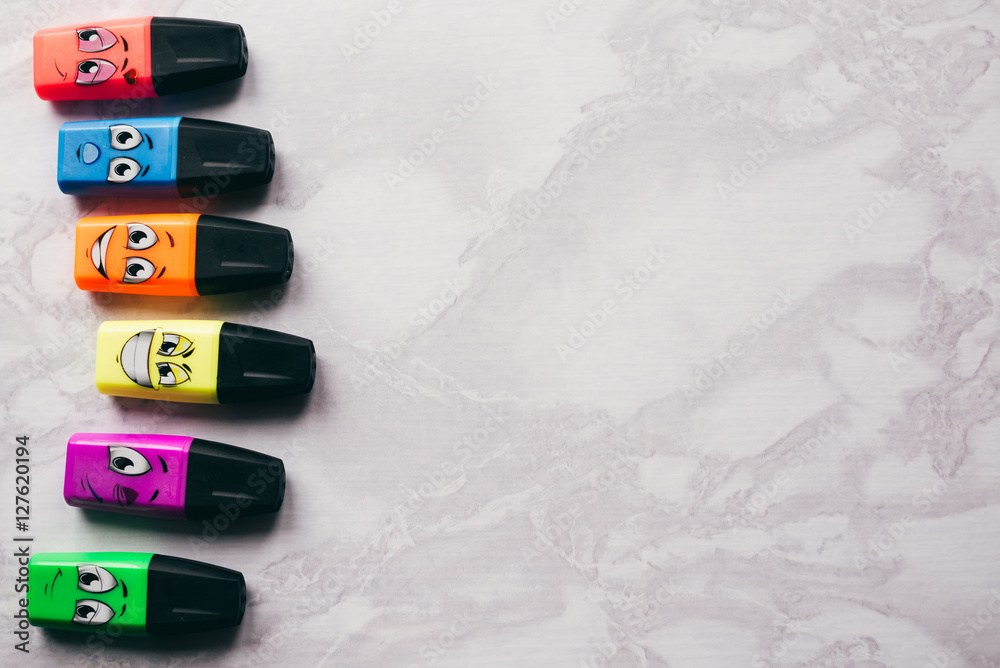 colored markers with funny faces and smiles. white background with copy ...