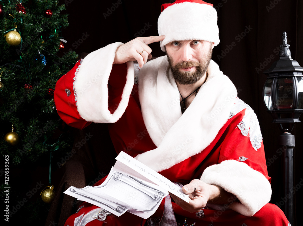 bad brutal Santa Claus discontentedly reads letter with wishes and ...