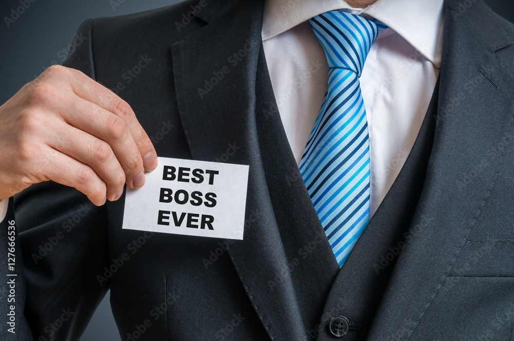 Self-confident businessman in suit is showing label that he is the best ...