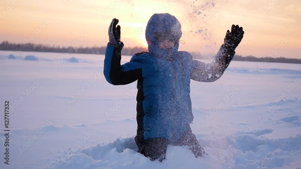 g child throwing snow over himself and enjoys it in winter park at ...