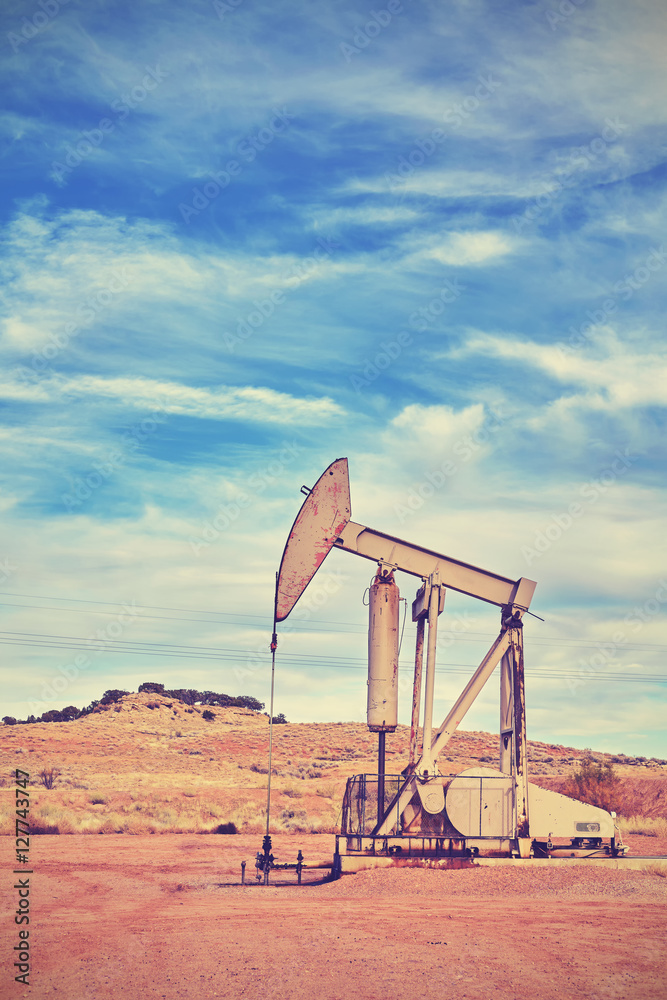Vintage toned picture of an oil pump, old industrial equipment on arid ...