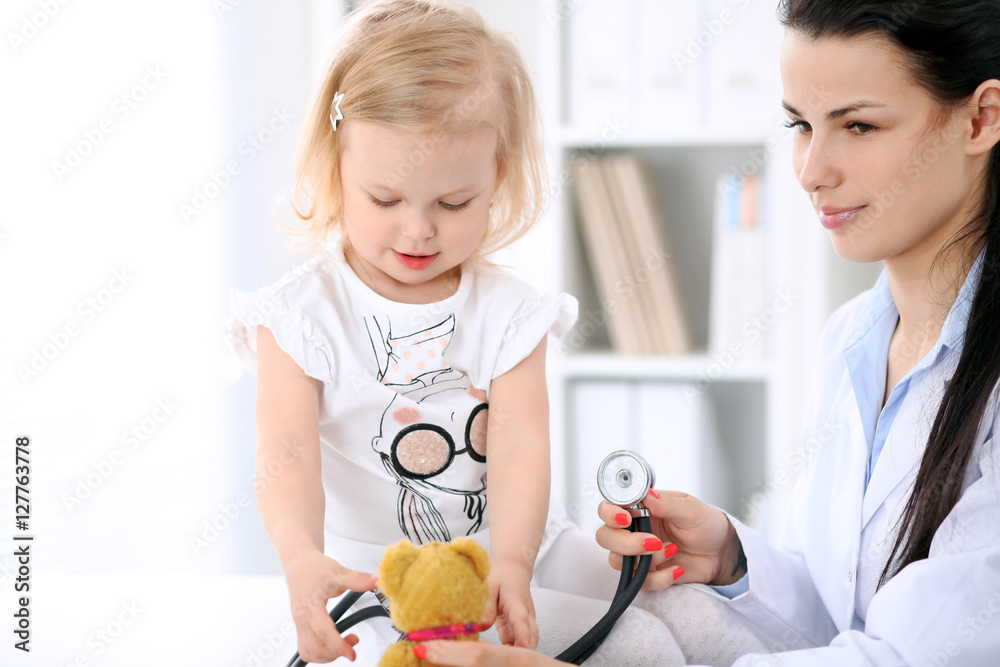 Pediatrician is taking care of baby in hospital. Little girl is being ...