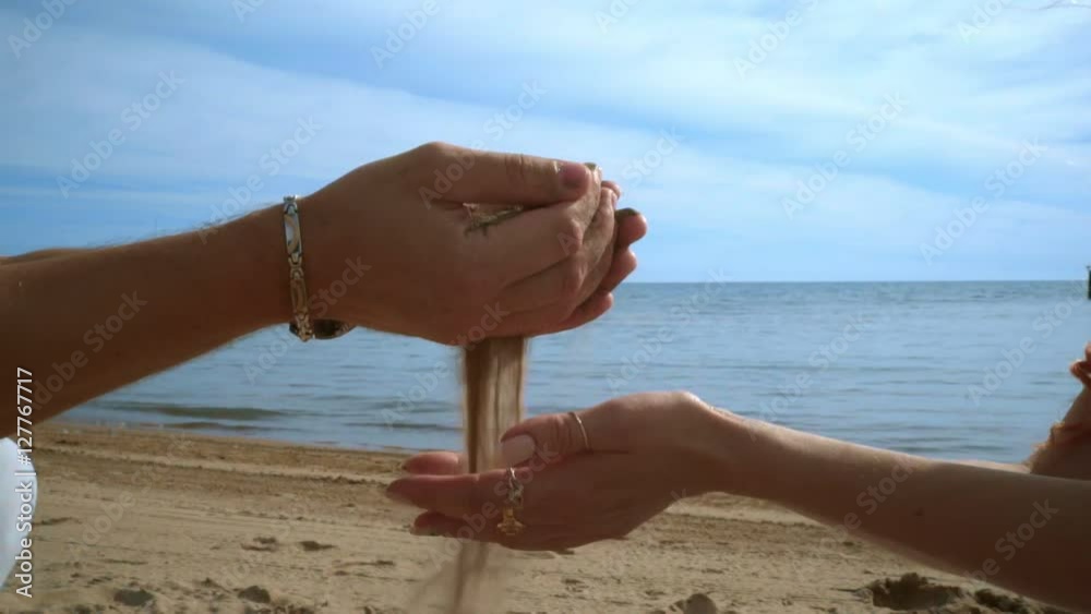 Love couple having fun on sand beach. Sand pouring from hands. Man and ...