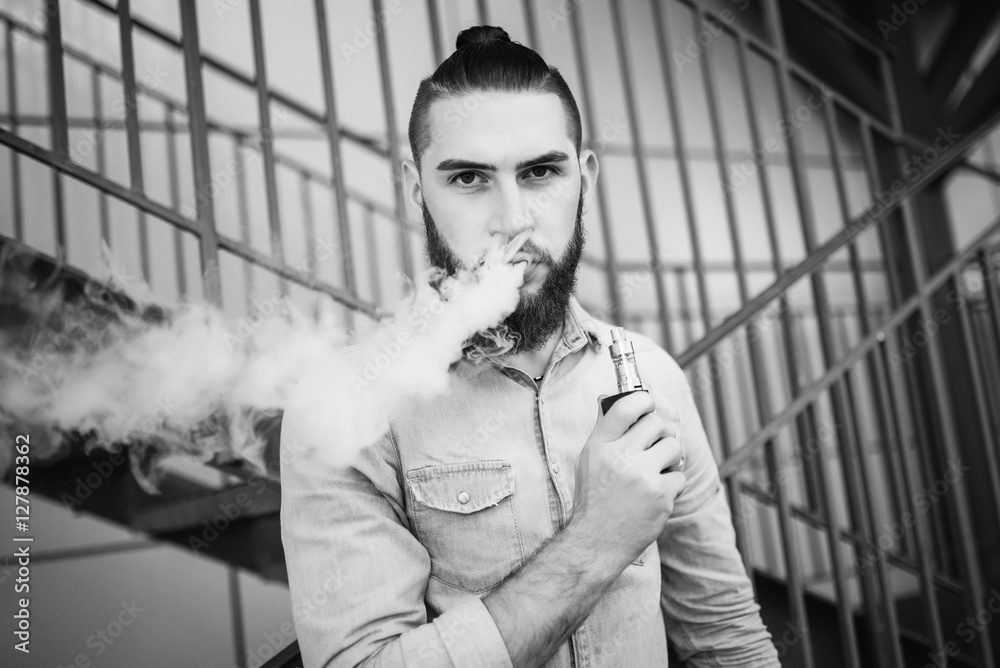 Vaping. Portrait of vaper vaping a vaporizer outdoors. Safe smoking ...