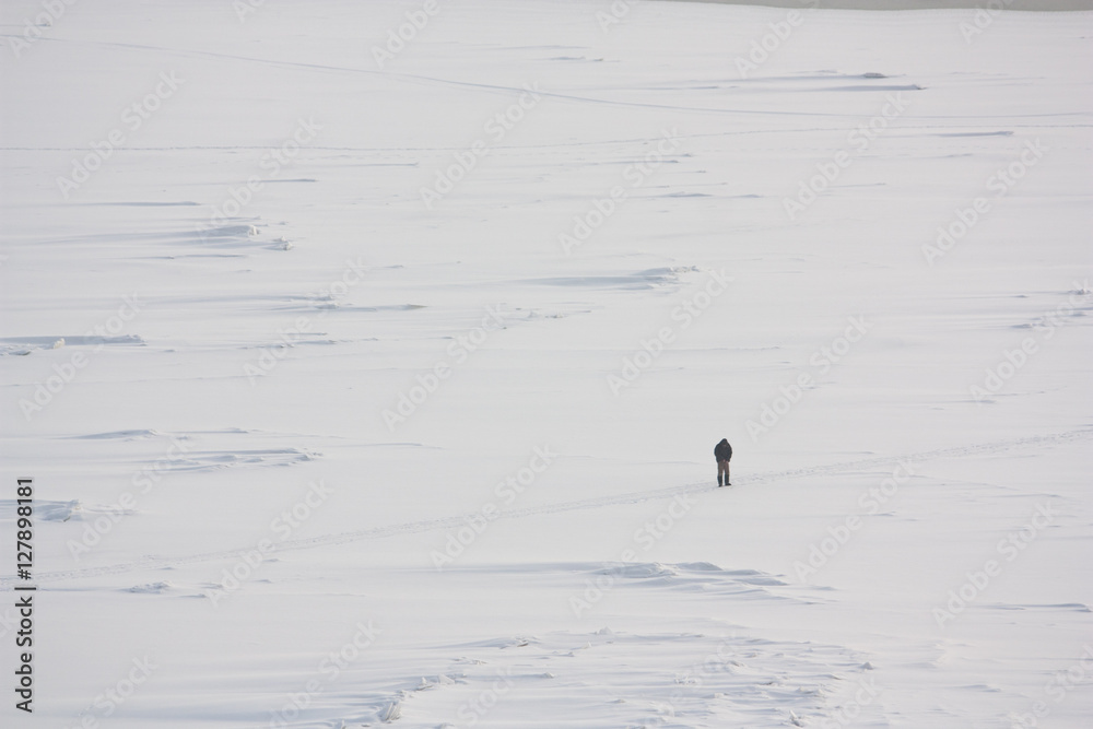 A man walks across the frozen river on ice and snow Stock Photo | Adobe ...