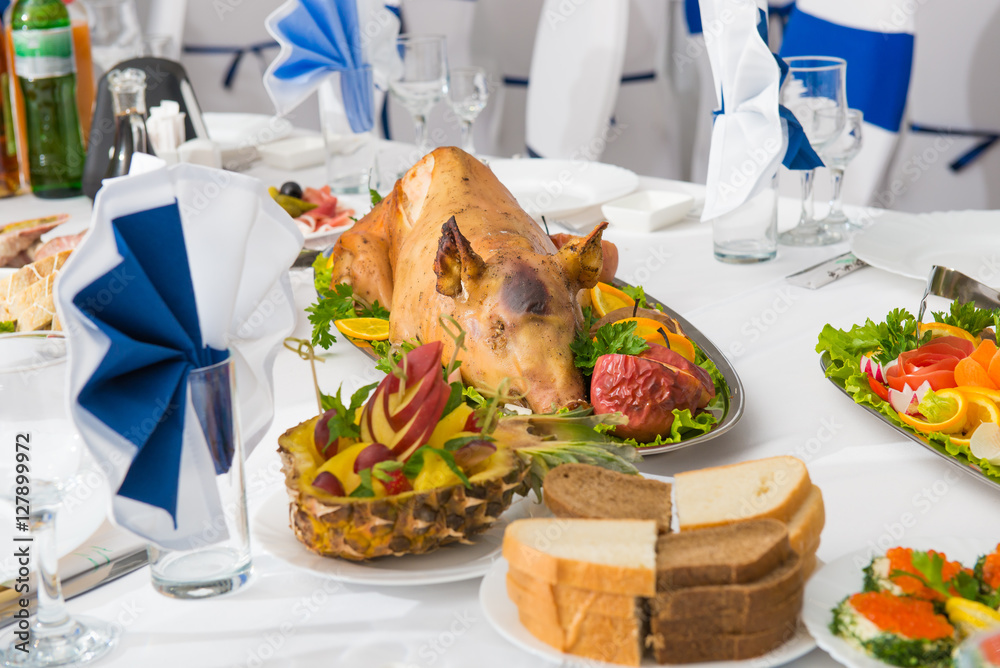 Roast pig. roasted piglet with vegetables on platter. Decorated table ...