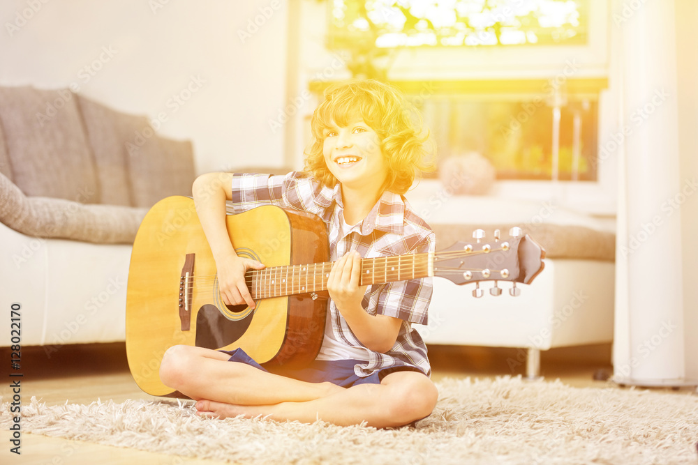 Happy boy singing and playing guitar Stock Photo | Adobe Stock