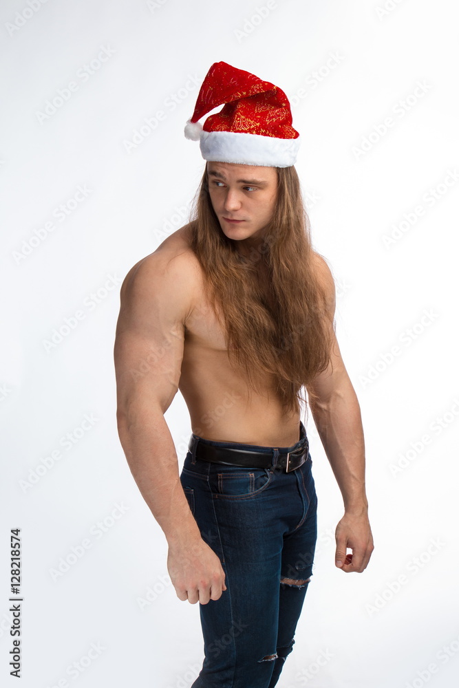 athlete bodybuilder shirtless with long hair posing in cap Santa Claus ...