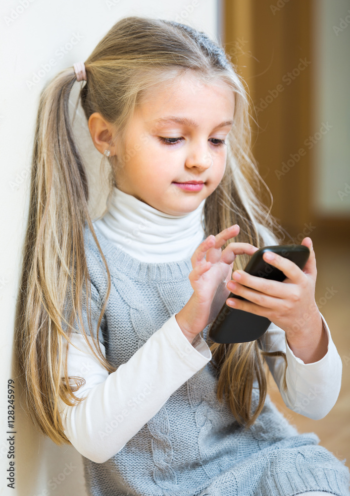 Little girl with cell phone indoors. Stock Photo | Adobe Stock