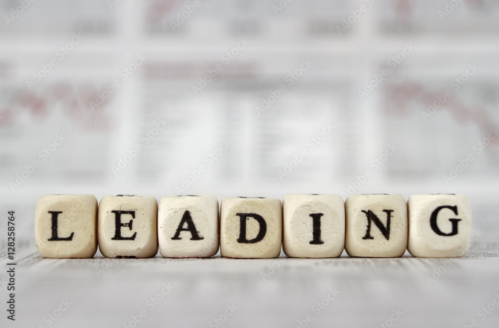 Leading word built with letter cubes on newspaper background Stock ...